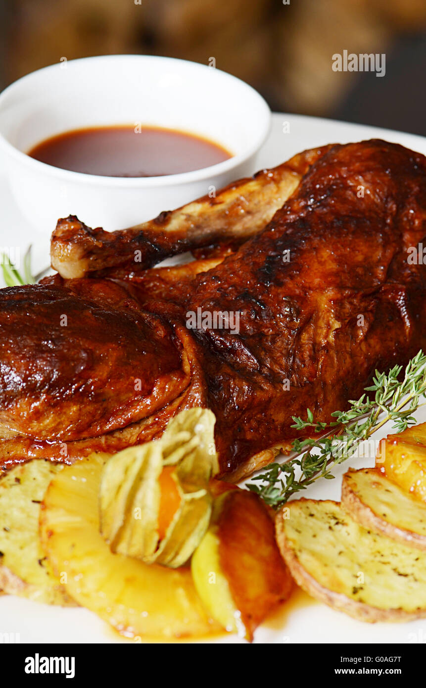 The baked half of duck with a potato, apples and pineapple Stock Photo ...