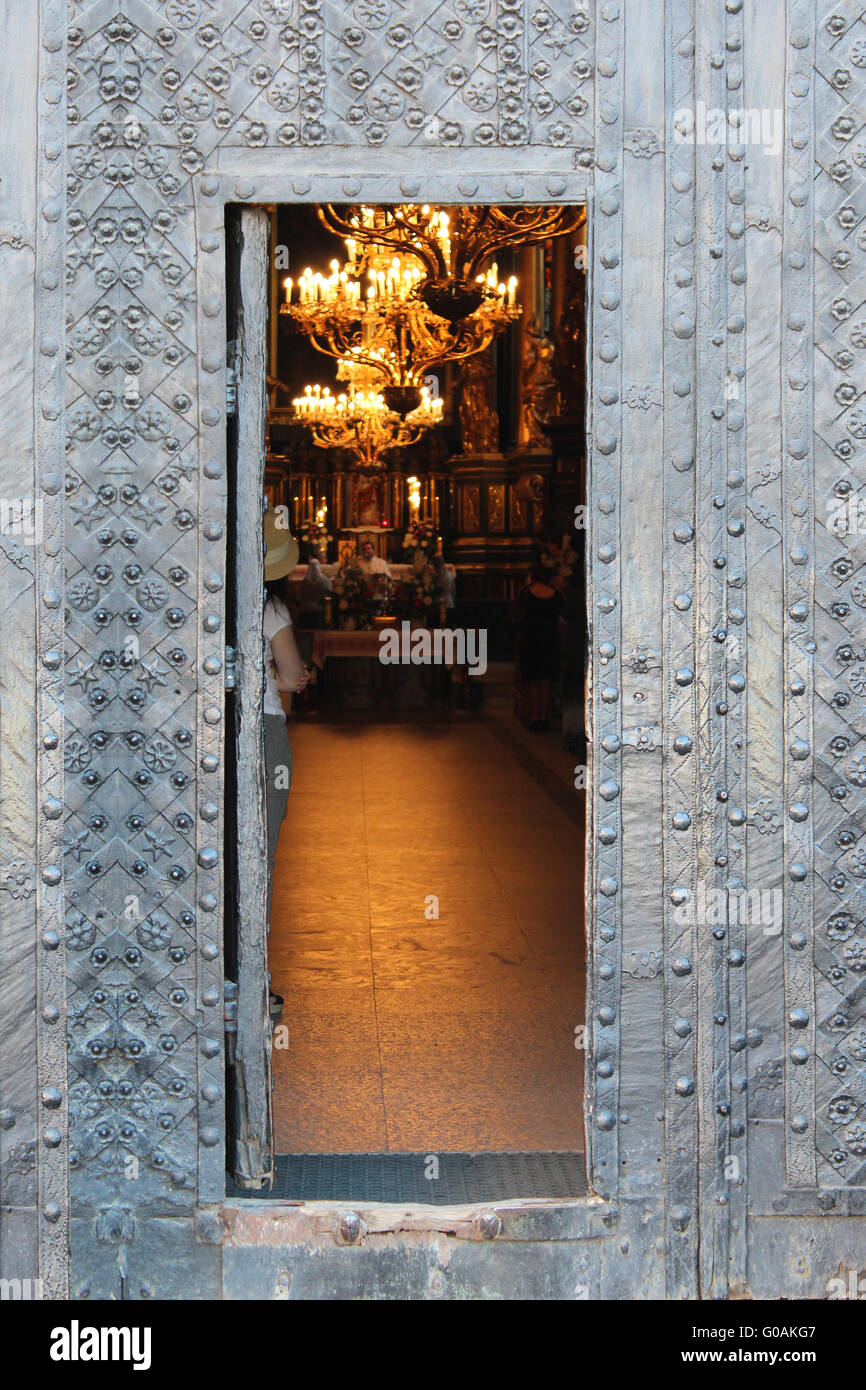 Opened church doors and lights inside church Stock Photo - Alamy