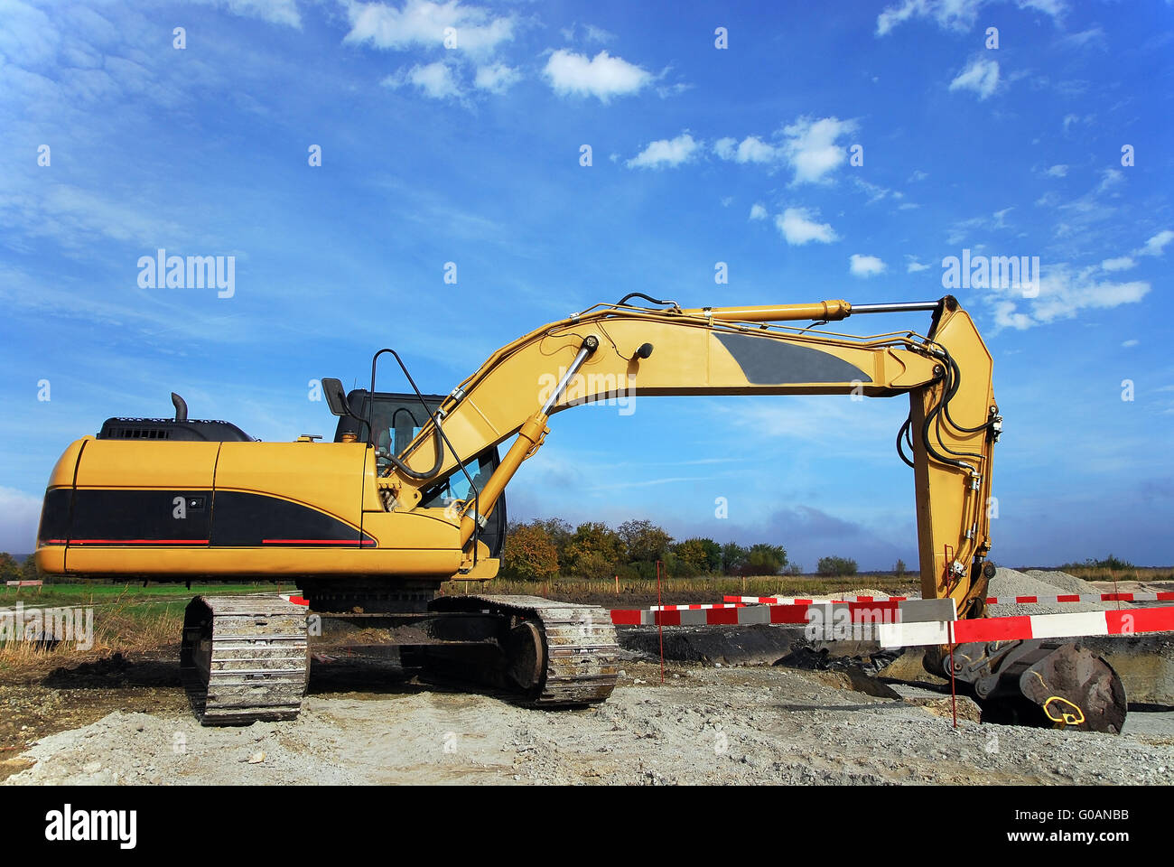 Excavator at construction site digging a hole Stock Photo - Alamy
