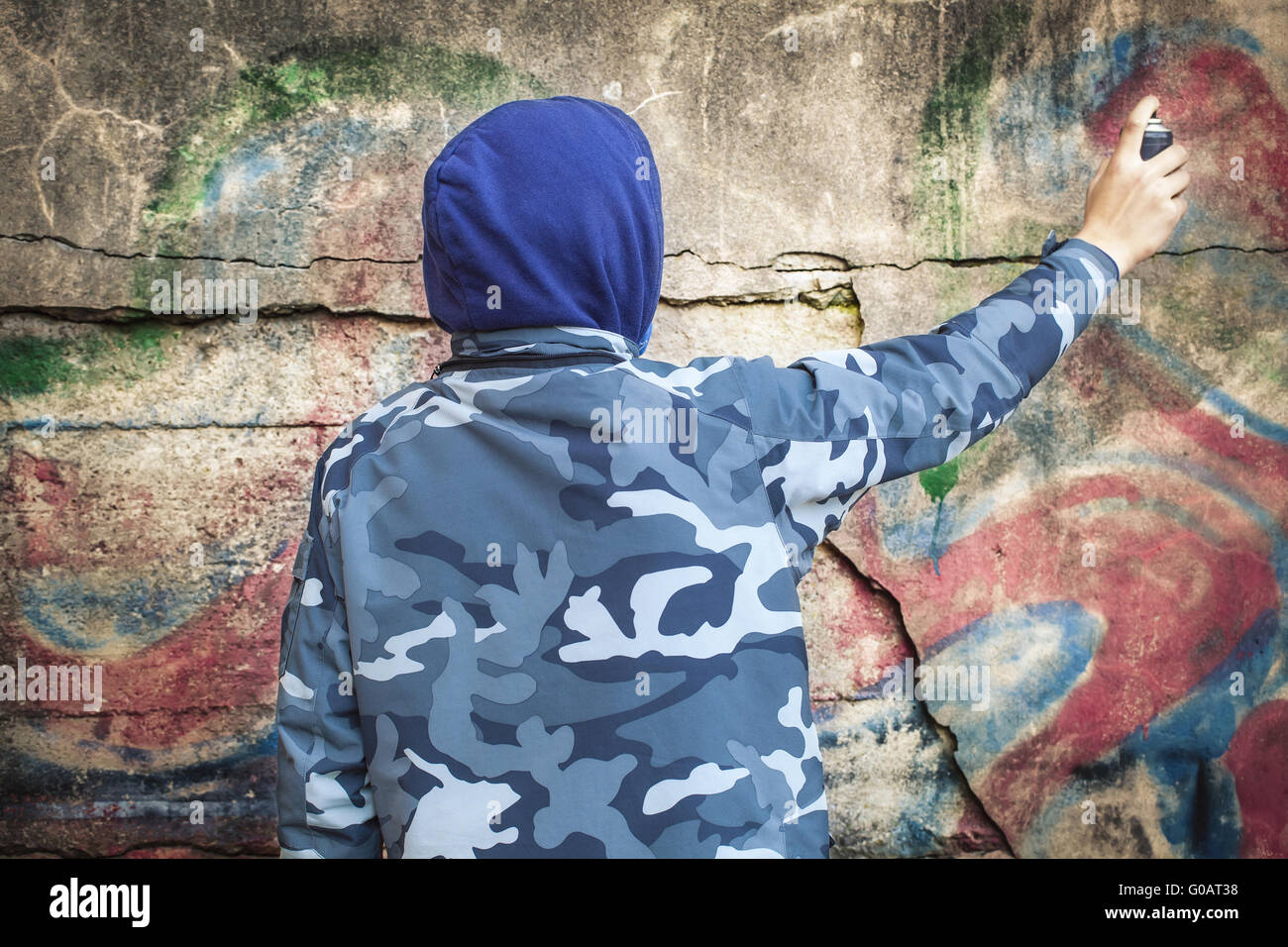 Boy with color spray can near the wall Stock Photo - Alamy