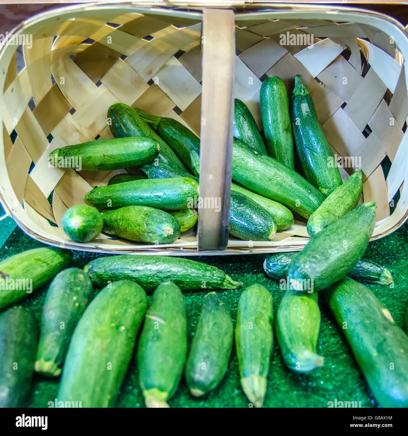 Fresh healthy green zucchini courgettes in basket on the marketplace ...