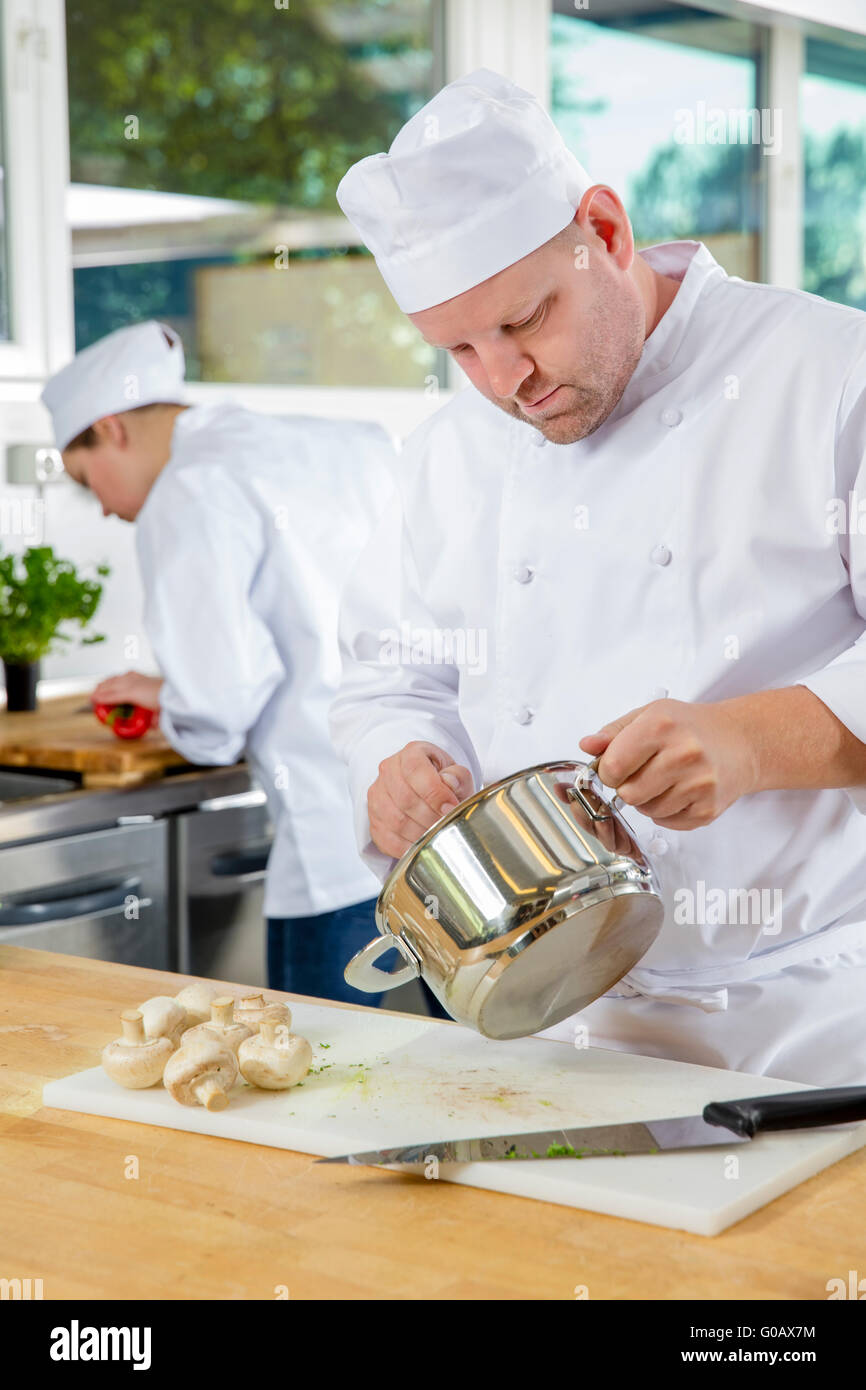 Professional chefs makes food dishes in large kitchen Stock Photo - Alamy