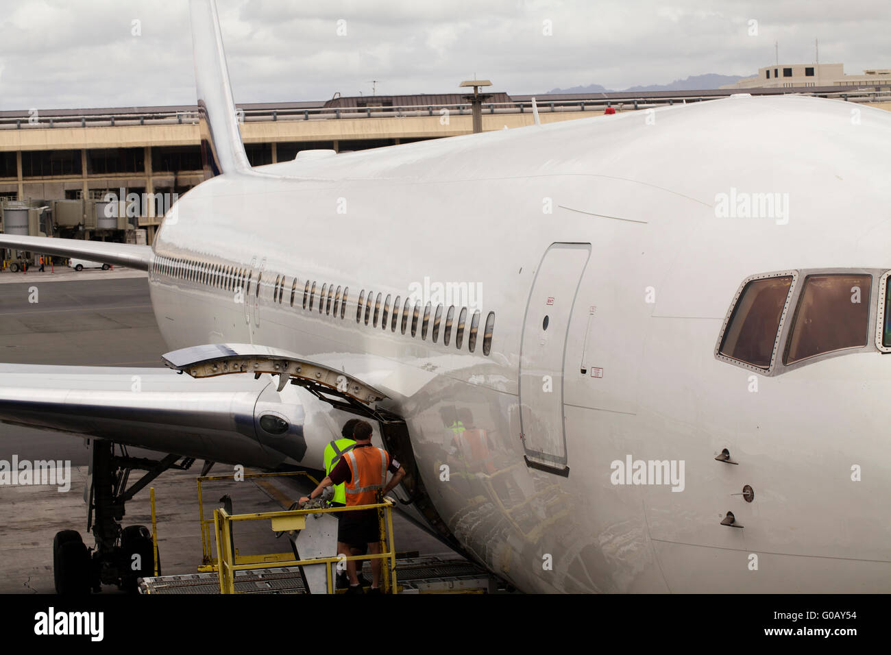 Small commercial jet at terminal workers at open hatch Stock Photo - Alamy