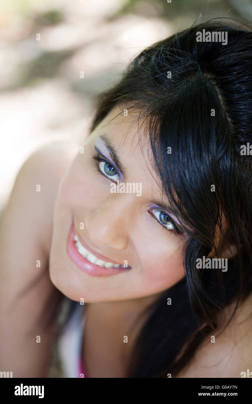 Young Latina woman smiling portrait outdoors looking up Stock Photo - Alamy