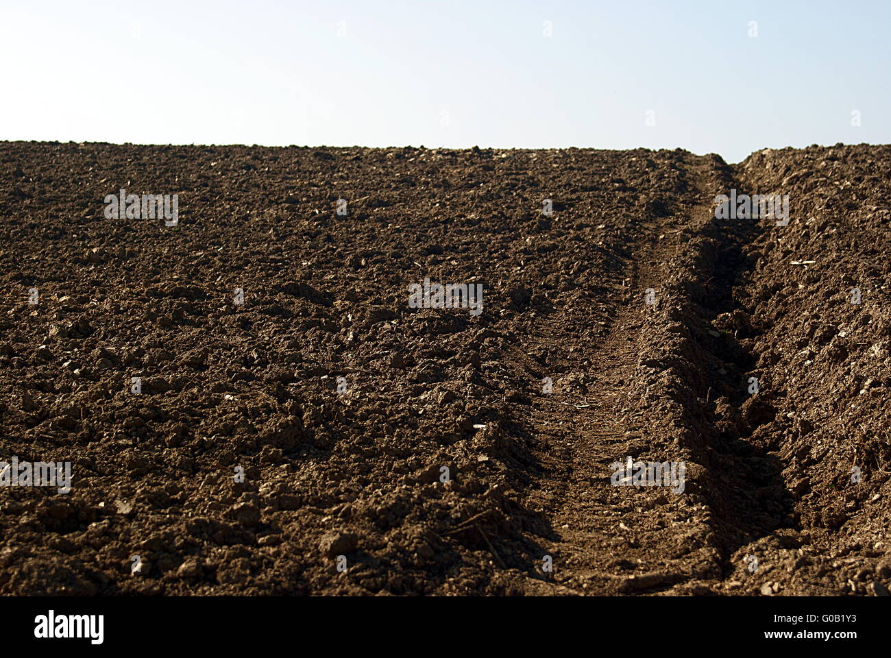Single furrow in front of blue sky Stock Photo - Alamy