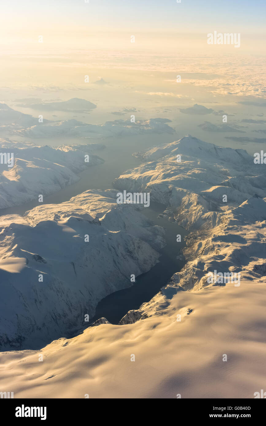 An aerial view of the snow covered mountains of the fjords of Norway in ...