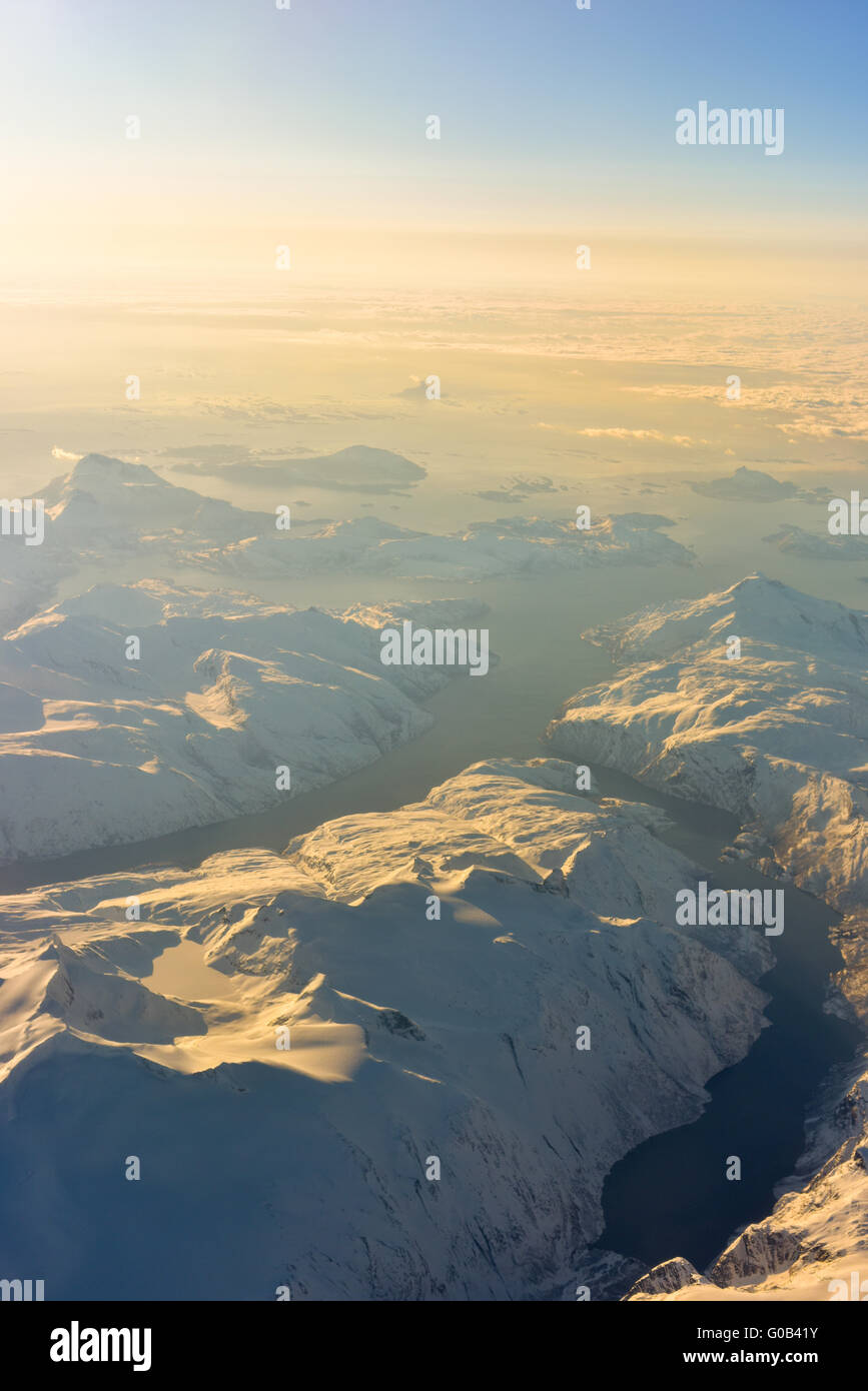 An aerial view of the snow covered mountains of the fjords of Norway in ...