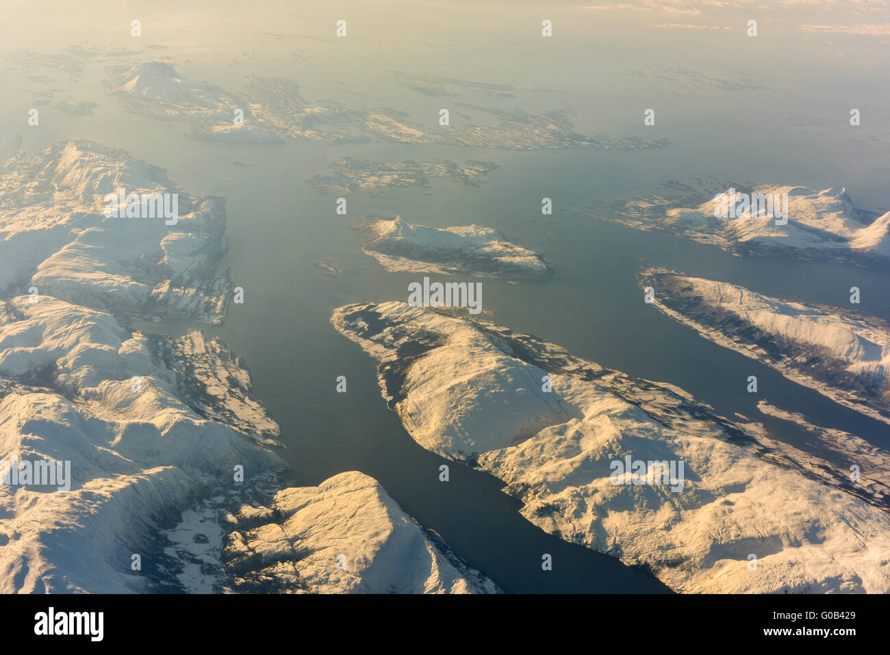 An aerial view of the snow covered mountains of the fjords of Norway in ...