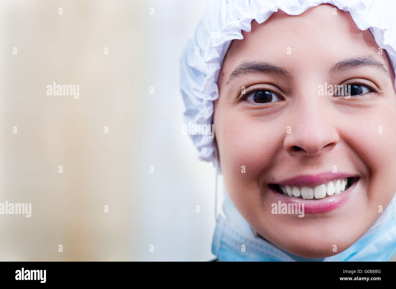 Closeup headshot female nurse wearing bouffant cap and smiling happily ...