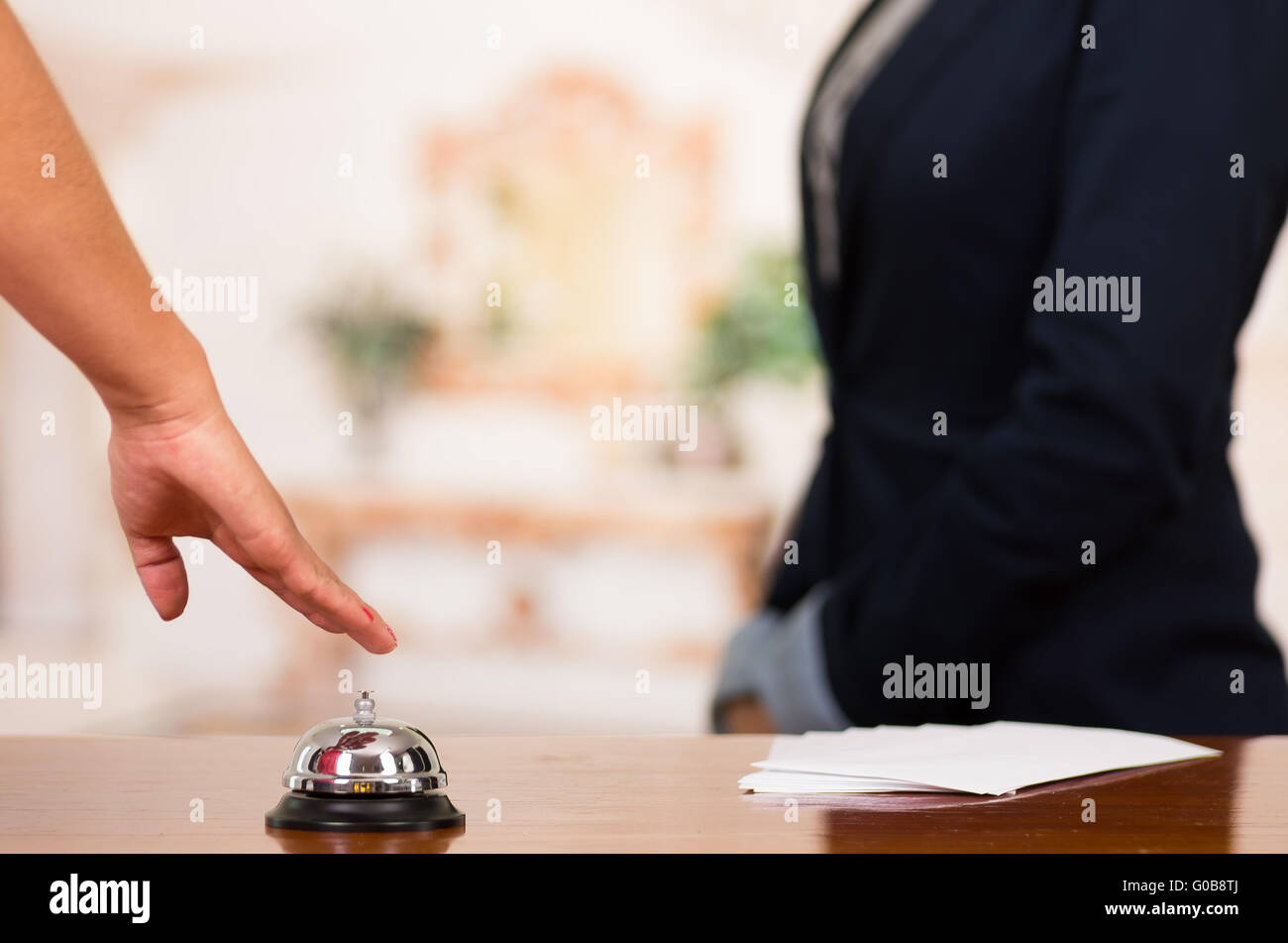 Closeup customer guest hand reaching for traditional reception bell ...
