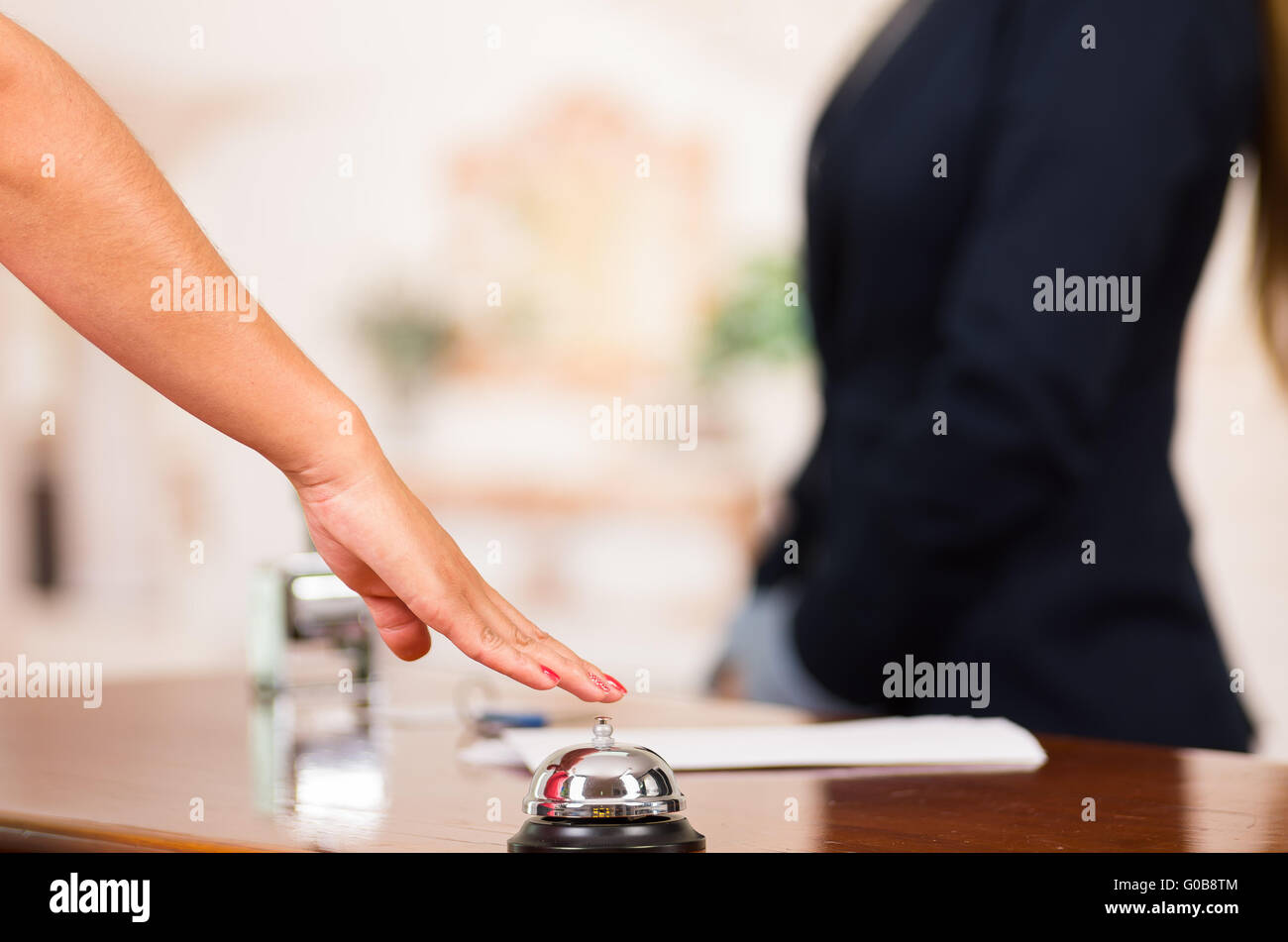 Closeup customer guest hand reaching for traditional reception bell ...