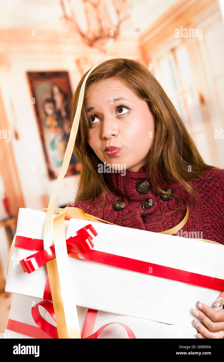 Brunette with beautiful smile holding up present happily posing for ...