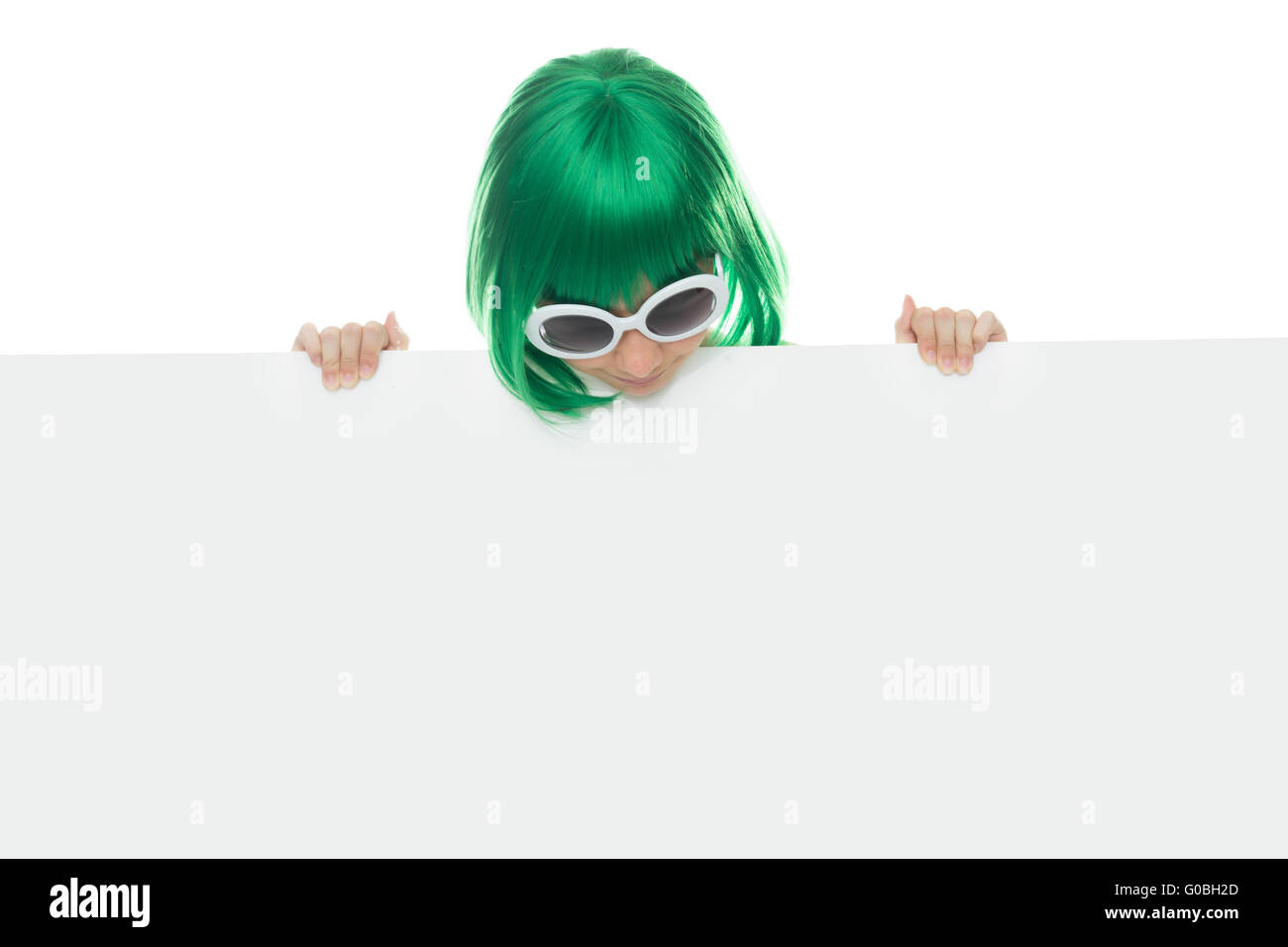 Cute young girl in a green wig holding a sign Stock Photo - Alamy