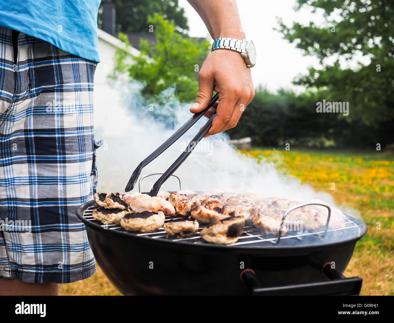Chef barbecuing with lots of smoke Stock Photo - Alamy