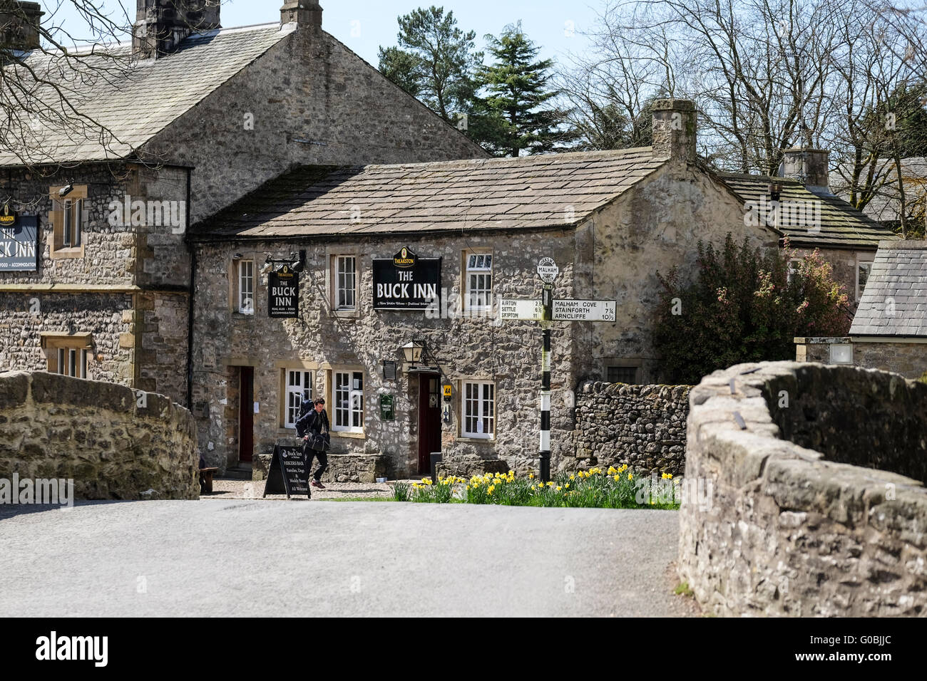 A walker passes The Buck Inn at Malham in the Yorkshire Dales Stock ...