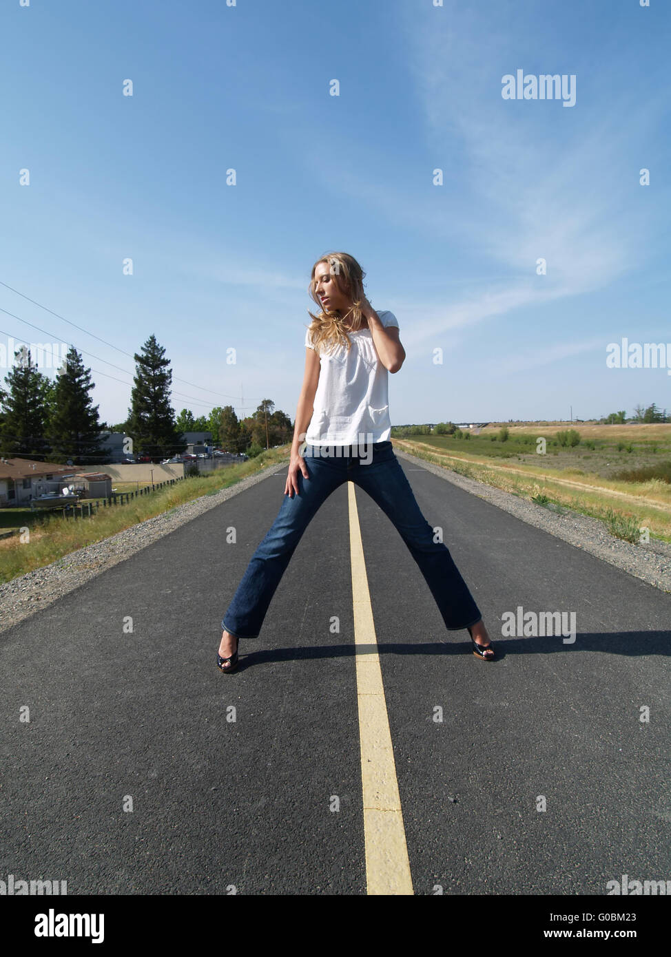 Young woman straddling center line on bike path Stock Photo - Alamy