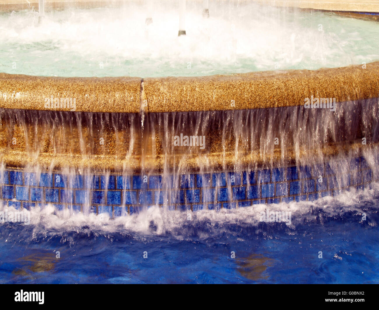 water in fountain flowing over edge of pool Stock Photo - Alamy