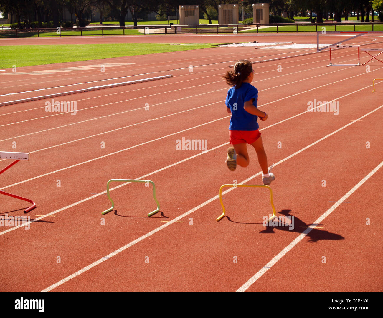 young girl jumping small hurdles on track Stock Photo - Alamy