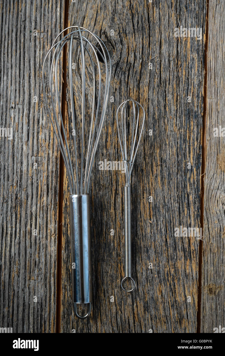 Large and Small Whisk on Rustic Wood Background Stock Photo - Alamy