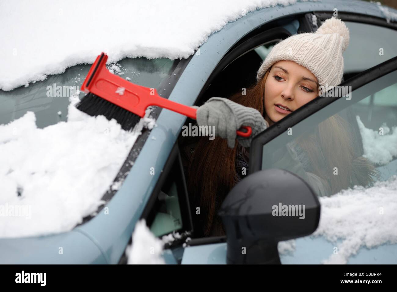 Young female sweeps snow off her car Stock Photo - Alamy