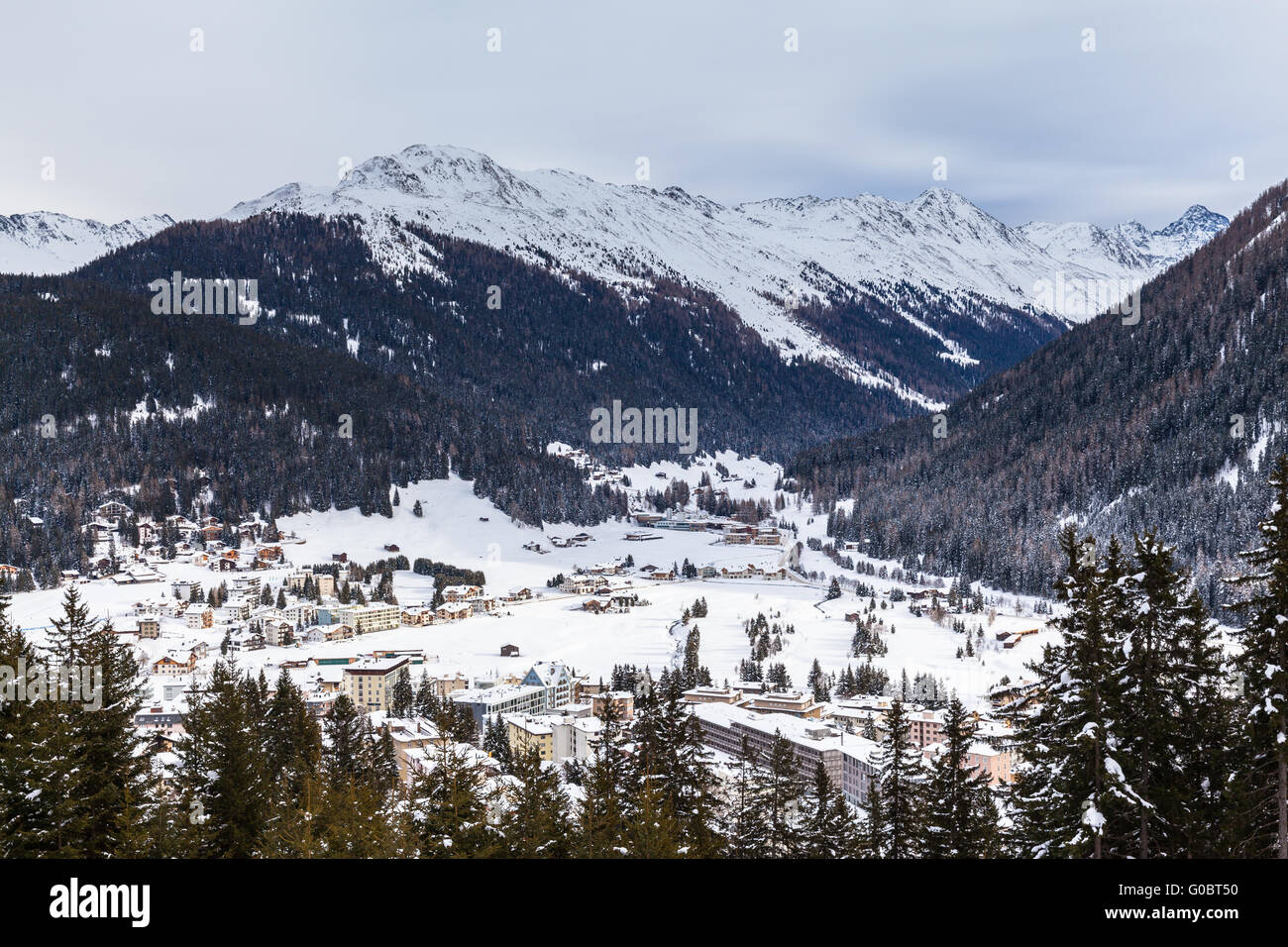 Aerial view of Davos in Winter with snow covered roofs and the Alps ...