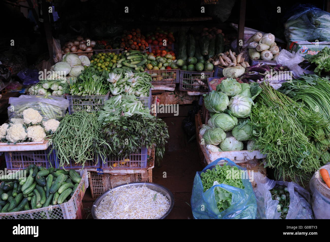 an open air vegetable stand at local market including cabbage ...
