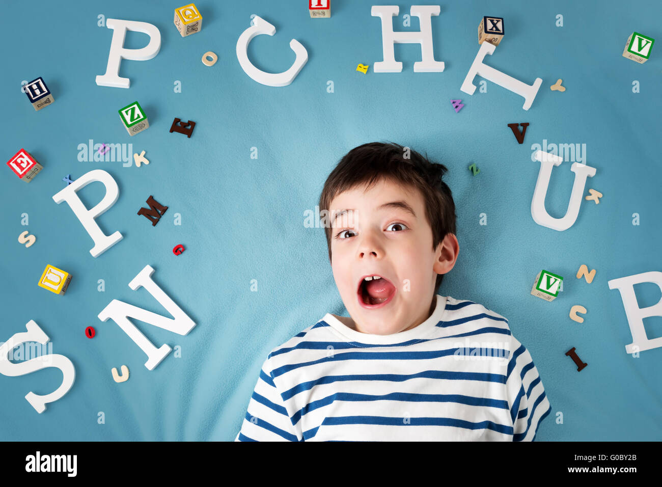seven years old child lying with letters Stock Photo - Alamy
