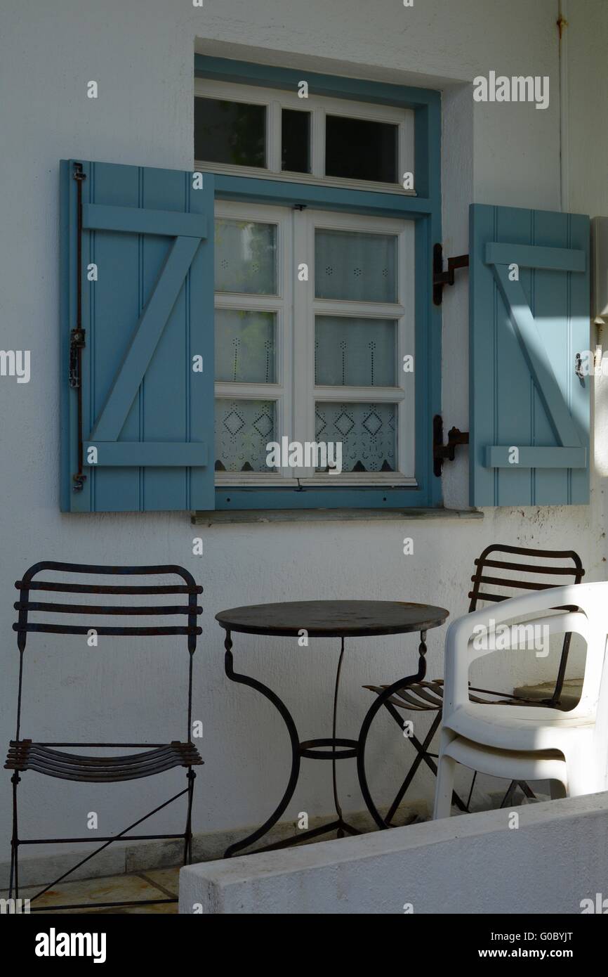 chairs and table under a blue painted window in skopelos greece Stock ...