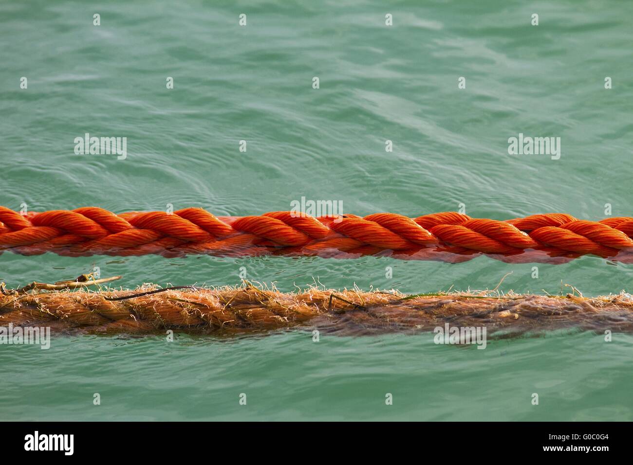 Ropes to the boat with water in the background Stock Photo - Alamy