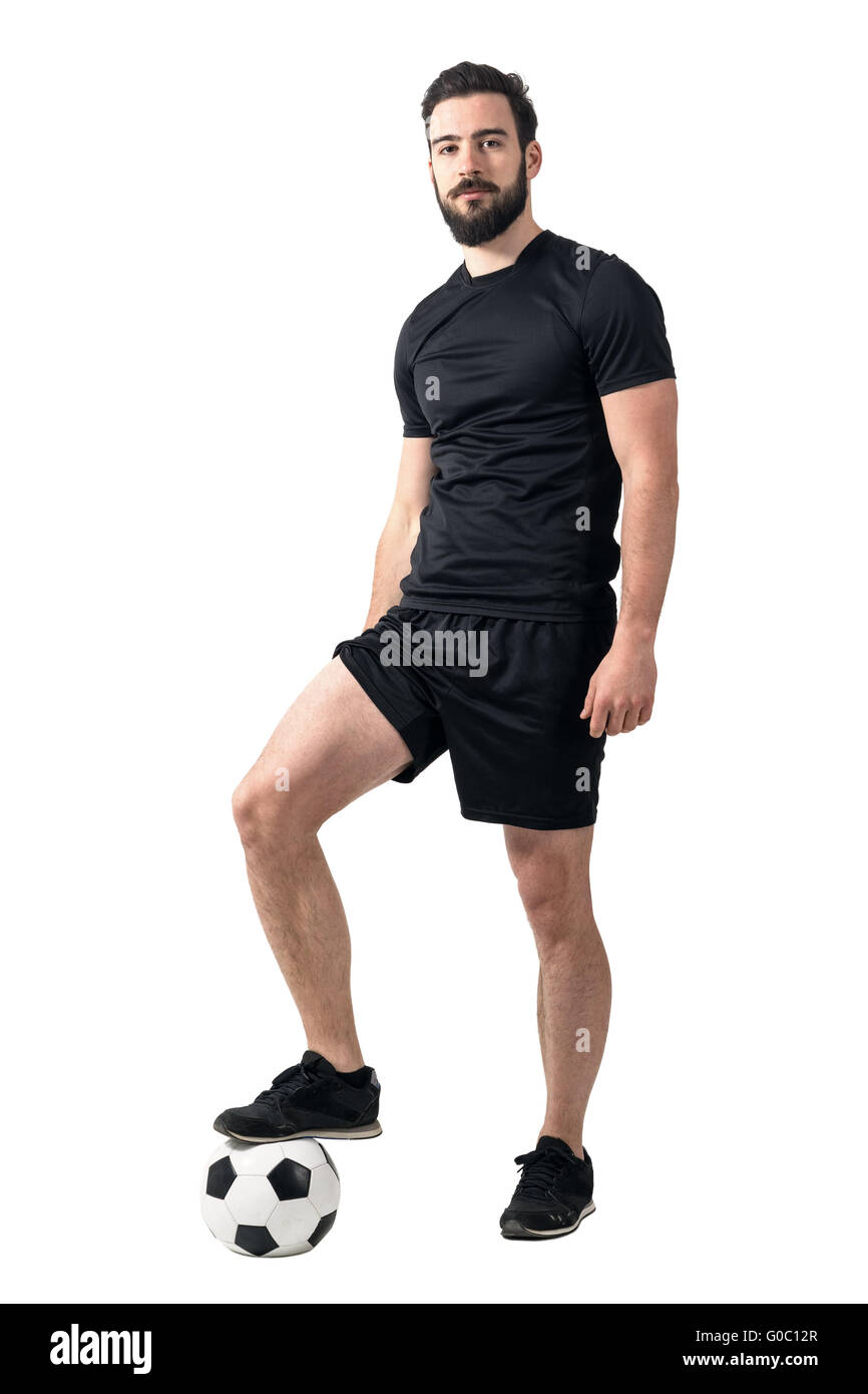 Relaxed serious soccer futsal player standing on the ball looking at ...