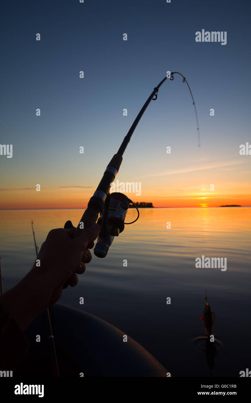 Sunset river perch fishing with the boat and a rod Stock Photo - Alamy