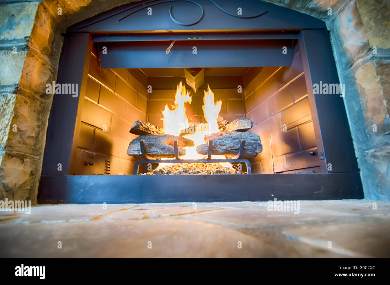 luxurious stone structure fireplace with burning fire Stock Photo - Alamy