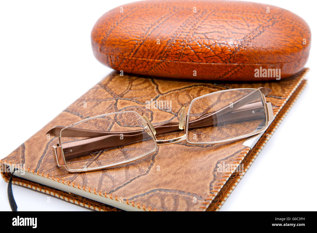 Leather notebook and glasses on a white background Stock Photo - Alamy