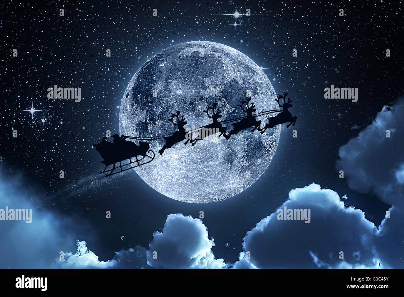 Santa flying in his sleigh against a full moon background with stars ...
