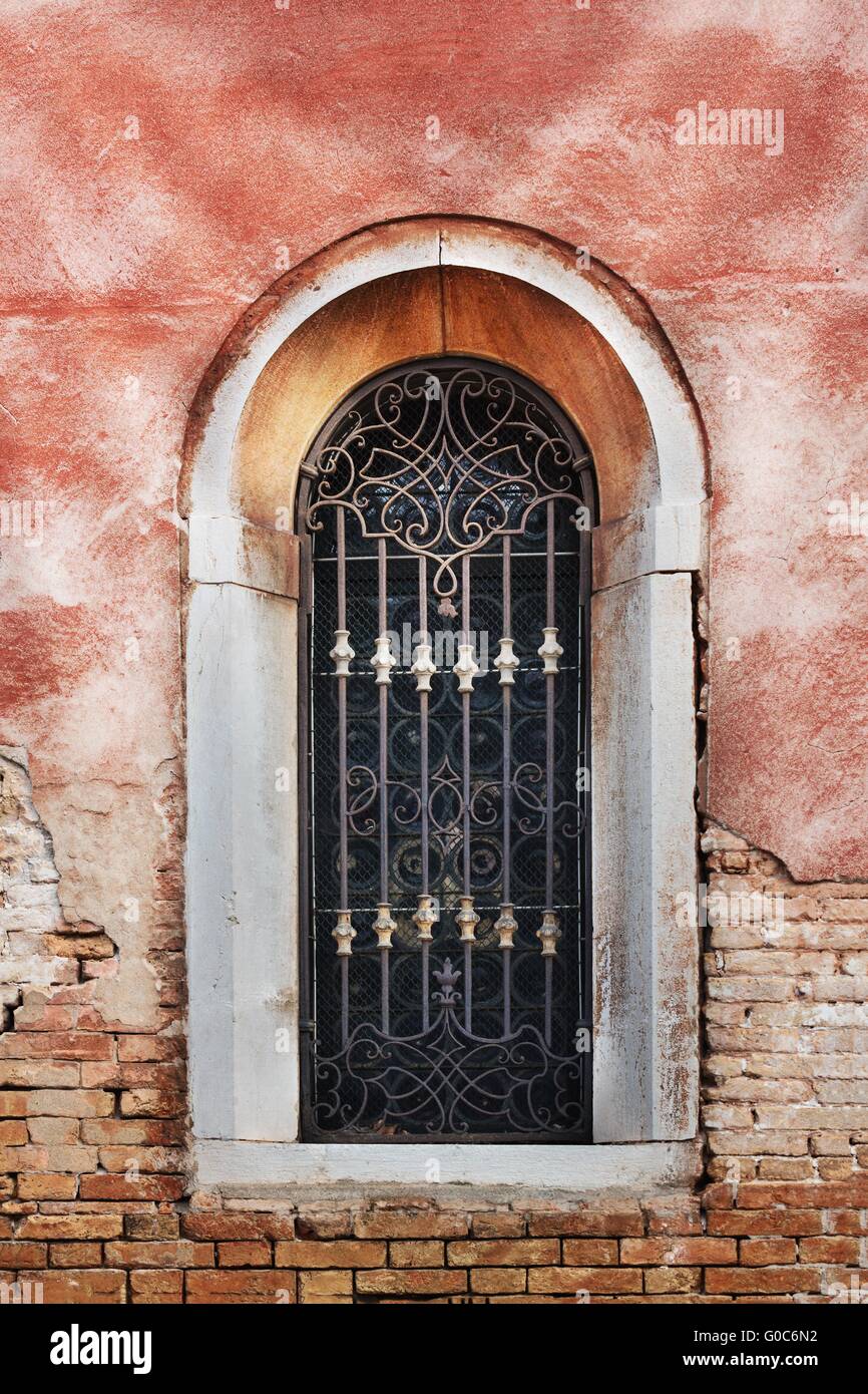 Old window with decorative bars on red facade Stock Photo - Alamy