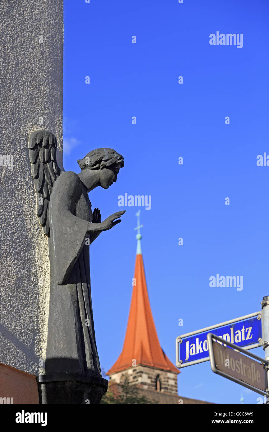 Angel statue on the wall and cathedral with road signs in Nuremberg ...