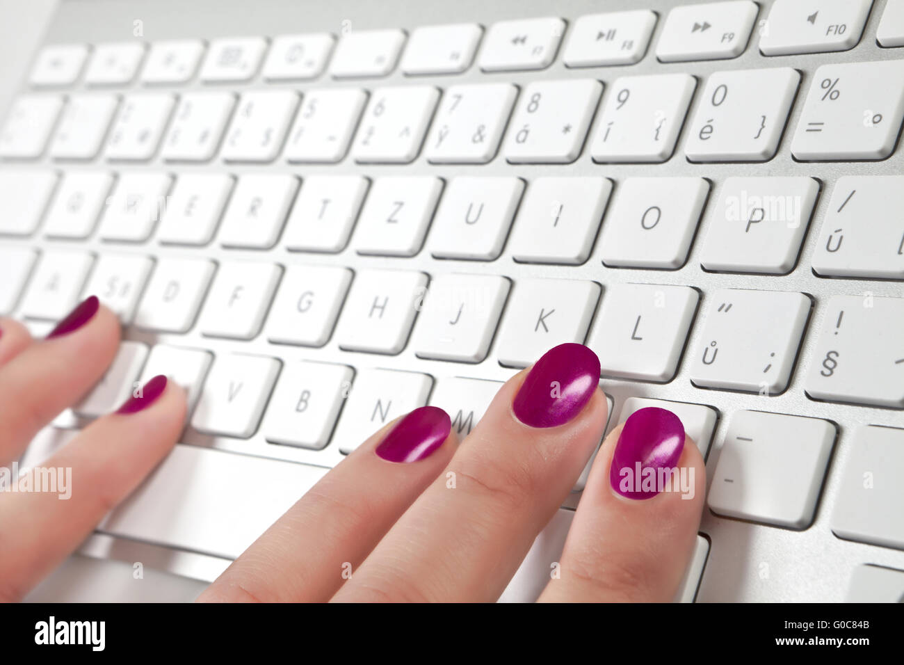 Close-up of female hand touching a white metal keyboard Stock Photo - Alamy