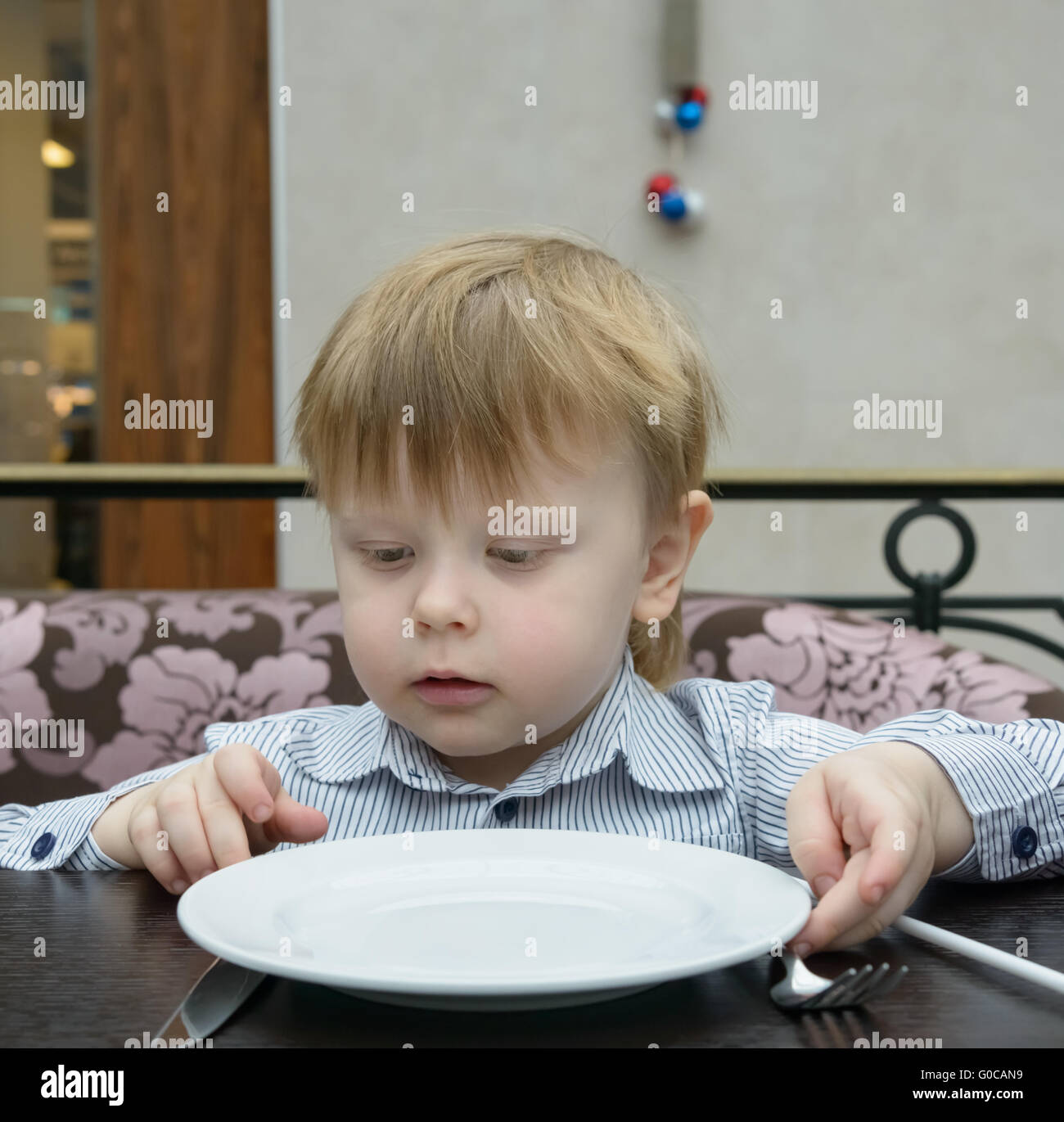Child blond boy sitting table hi-res stock photography and images - Alamy
