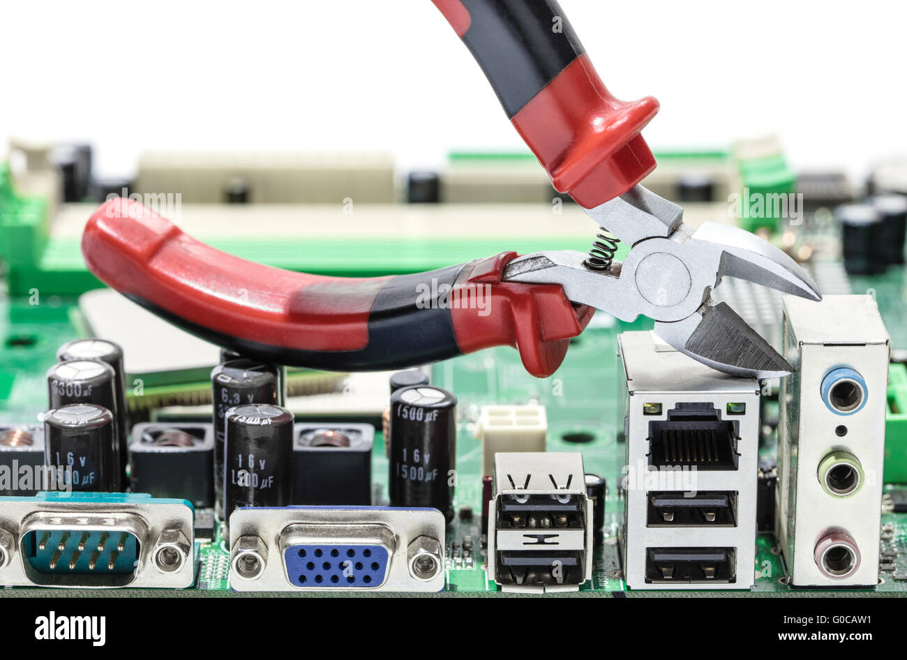 nippers close-up on computer circuit board background Stock Photo - Alamy