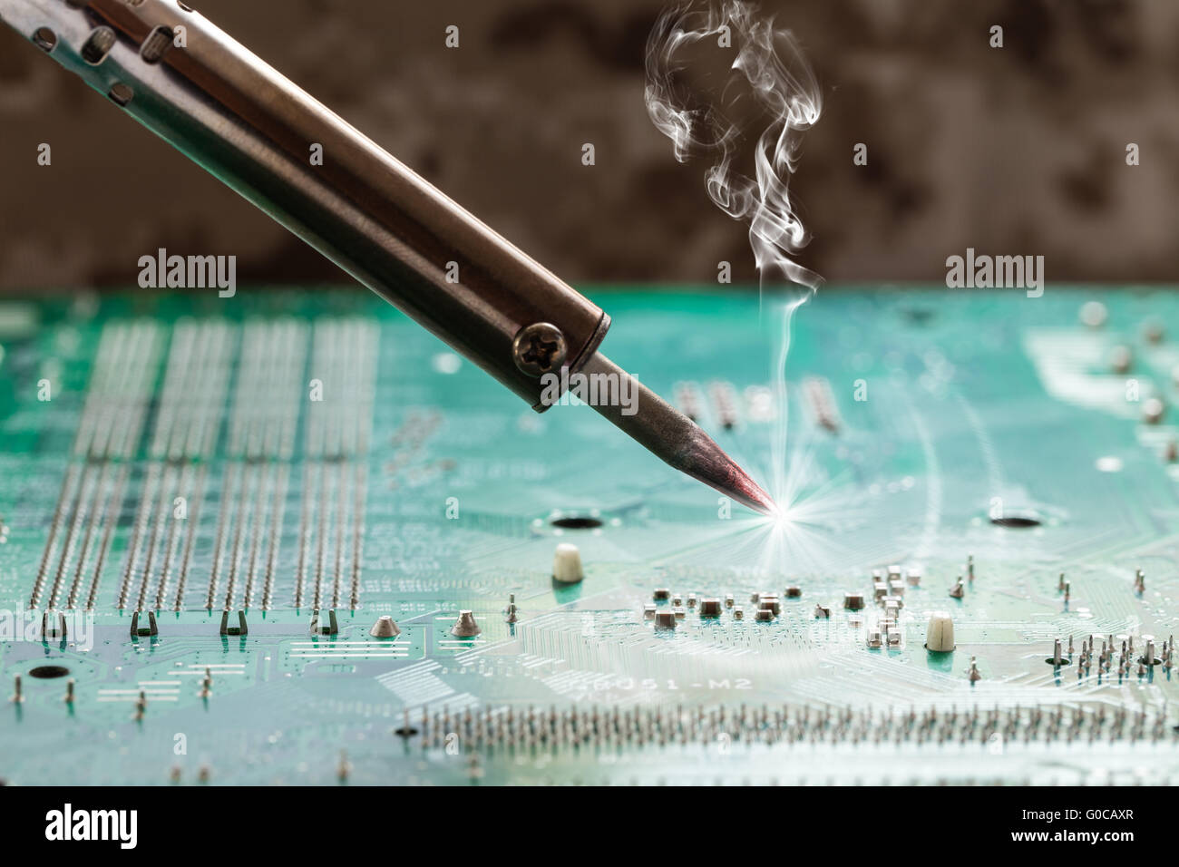 smoking soldering iron on a computer motherboard closeup Stock Photo ...