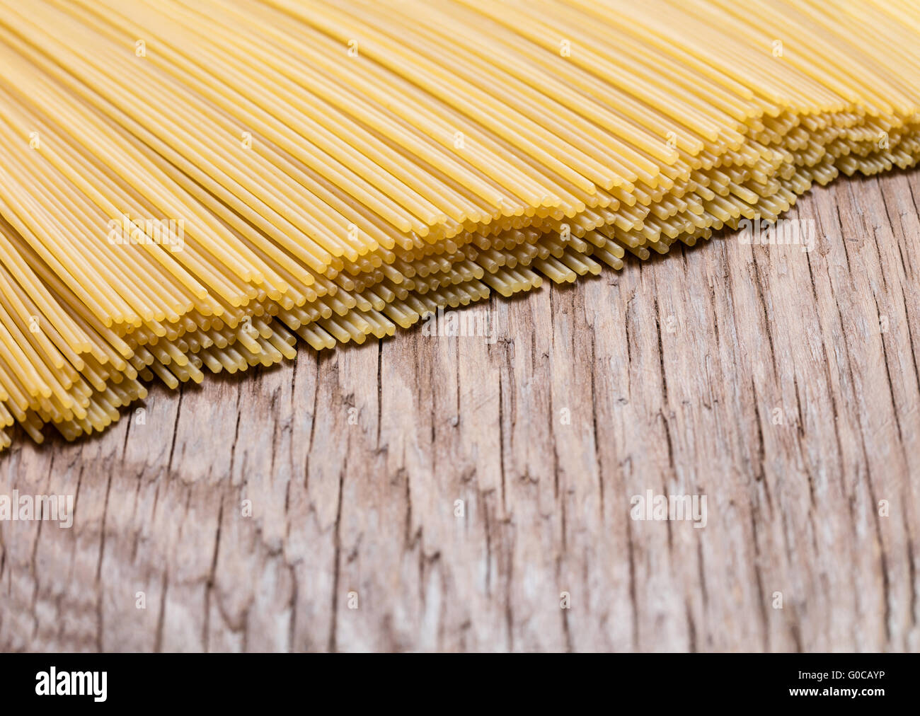 uncooked spaghetti closeup on the wooden background Stock Photo - Alamy