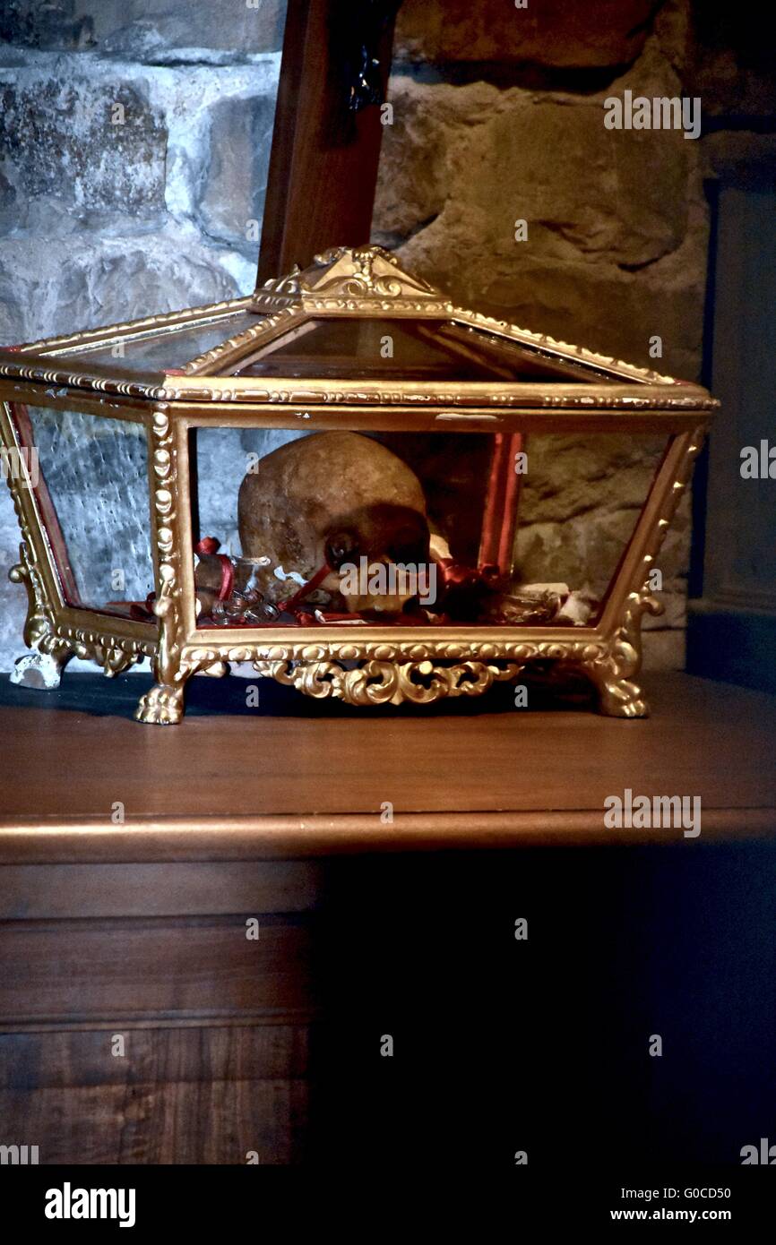 A skull contained inside a small cage in the dungeon of a cathedral ...