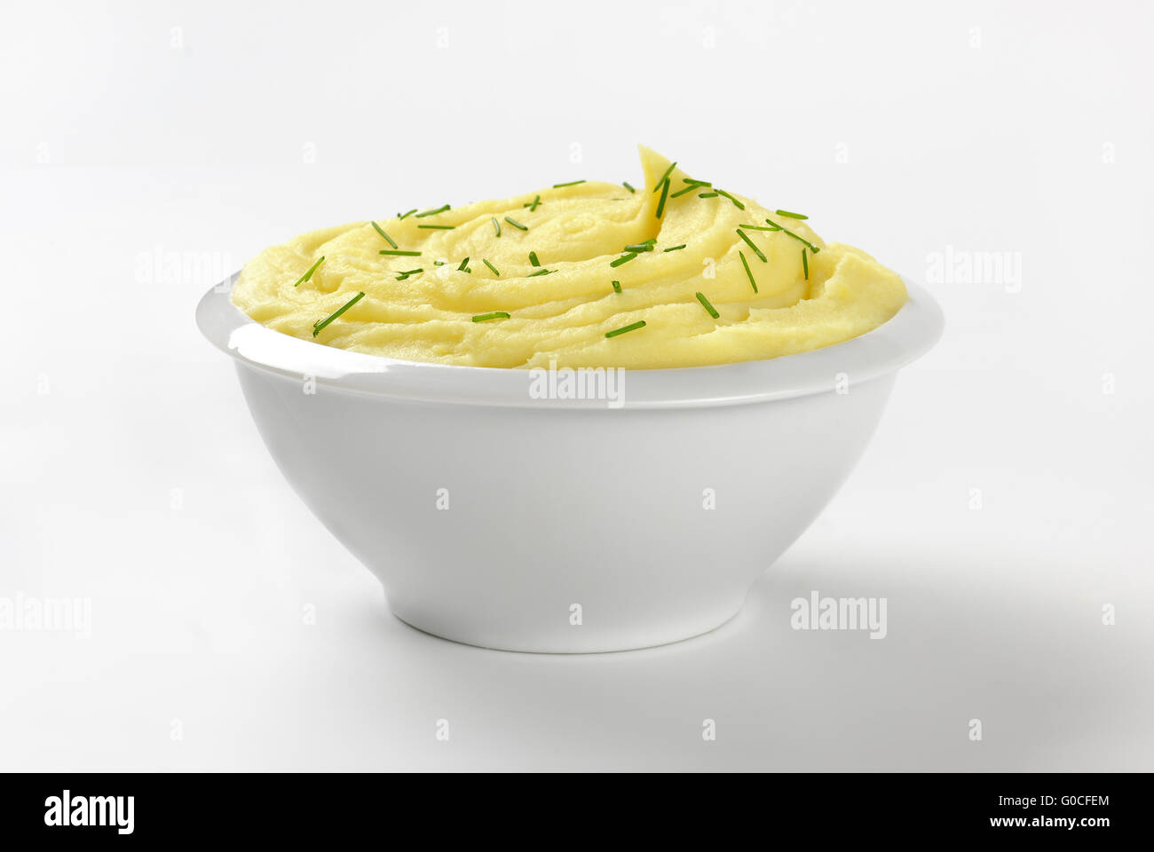 bowl of mashed potato puree with chopped chives on white background ...