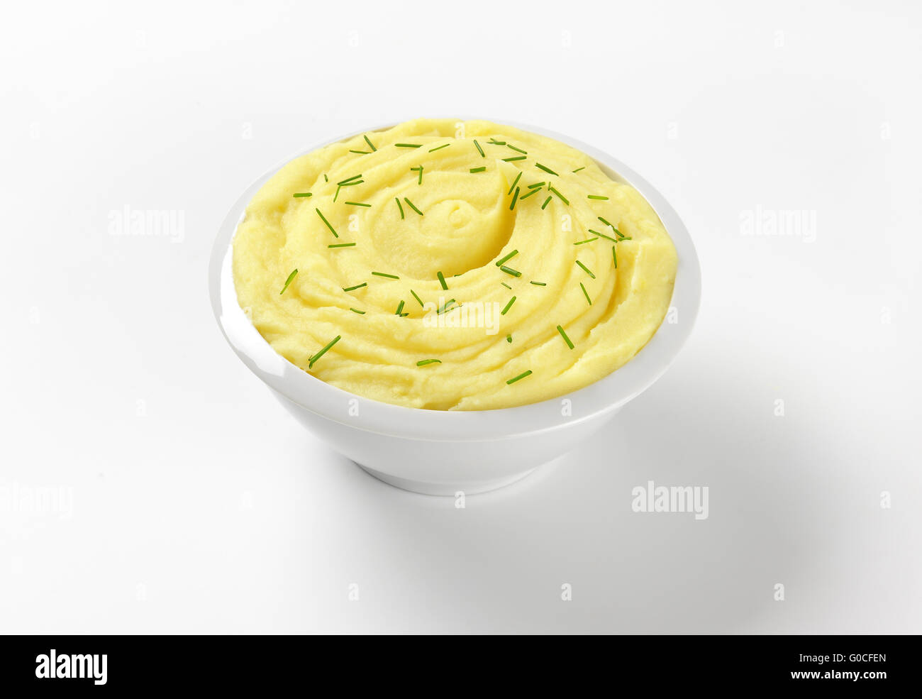 bowl of mashed potato puree with chopped chives on white background ...