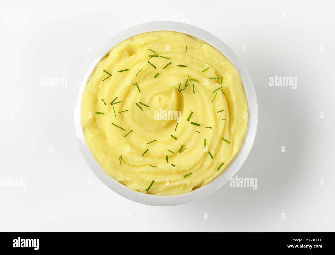 bowl of mashed potato puree with chopped chives on white background ...