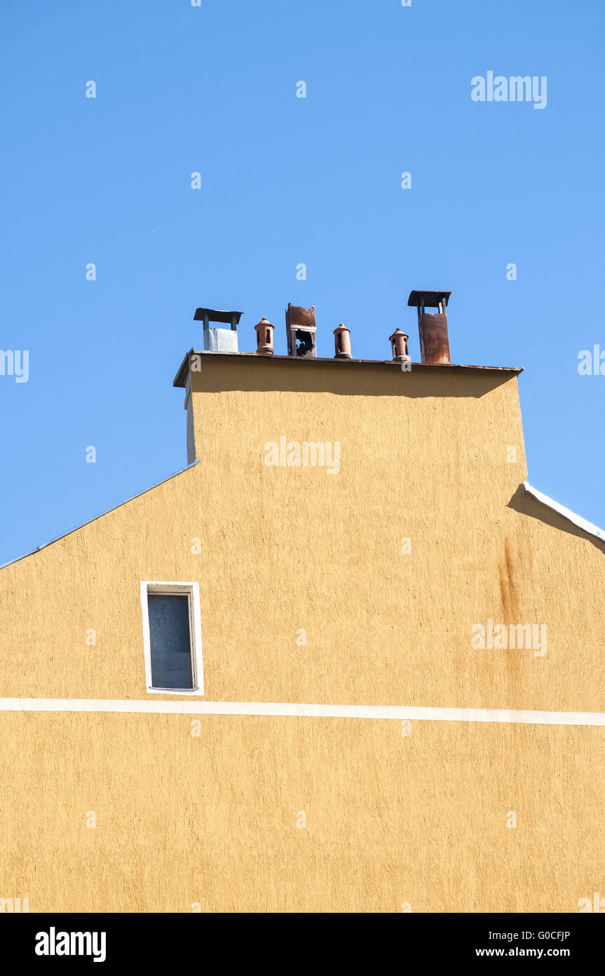 Chimney section of yellow house wall with differen Stock Photo - Alamy