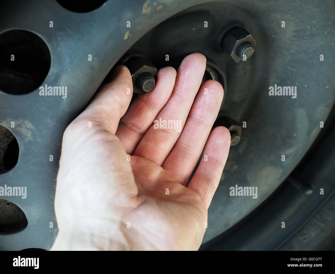 Hand checking nuts and bolts on steel wheel Stock Photo - Alamy