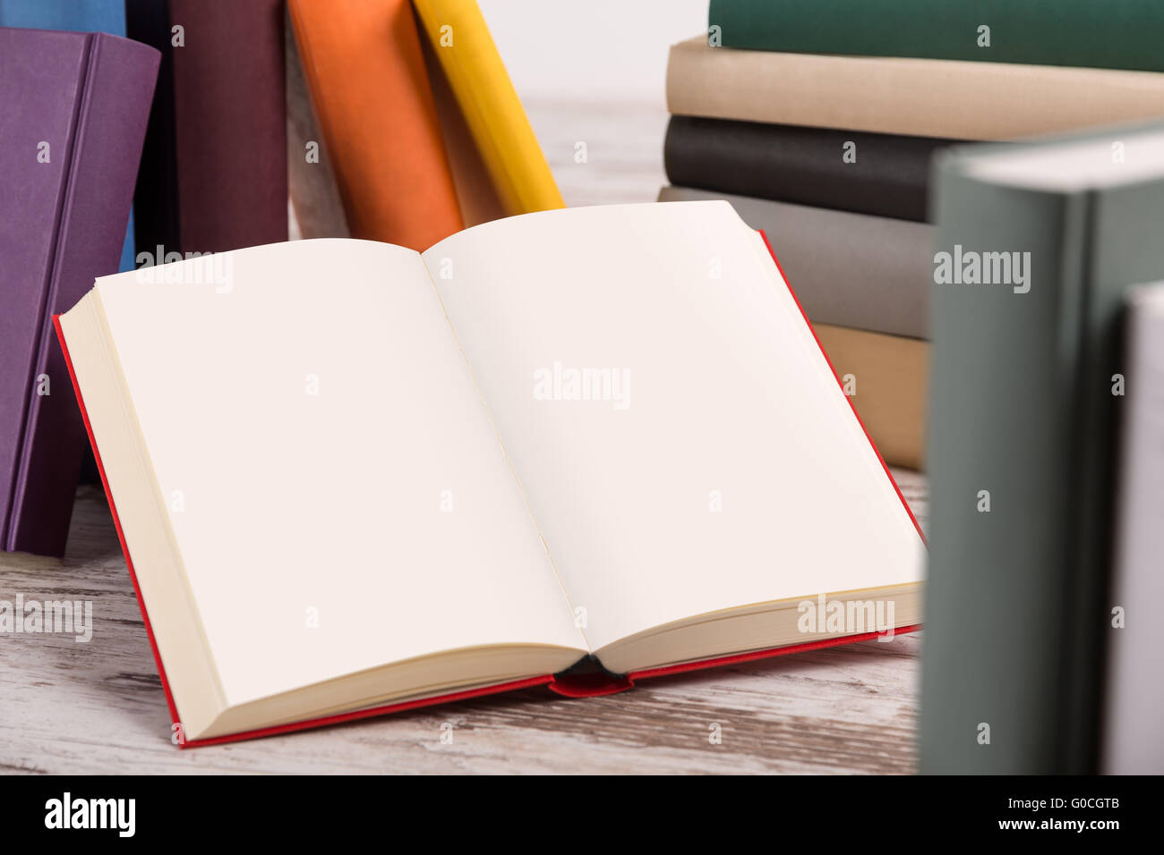 A set of different colored books with an open one Stock Photo - Alamy