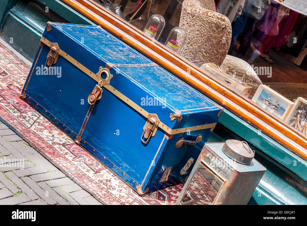 Large, old, blue travel chest at the window of a s Stock Photo - Alamy