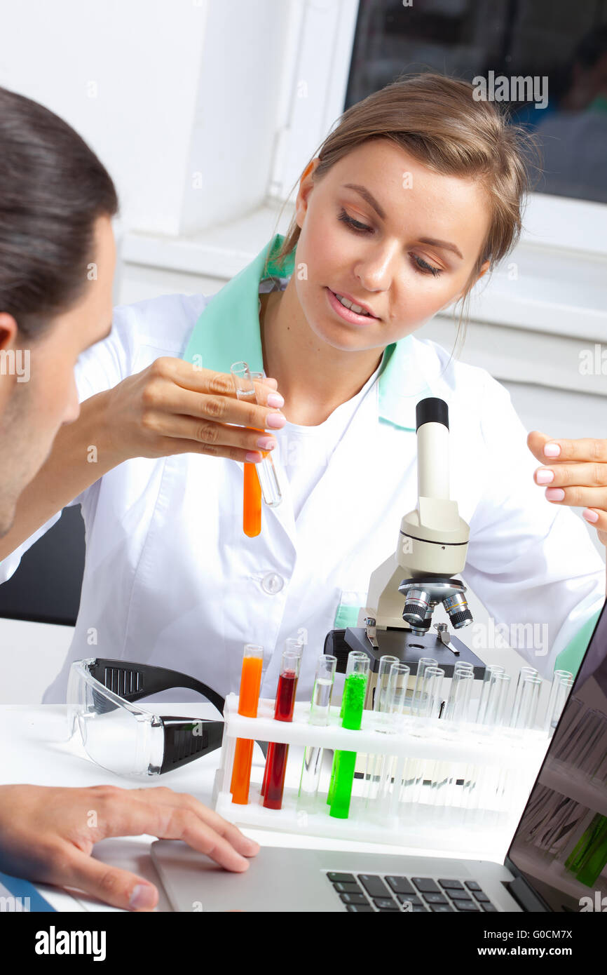 Closeup of a blurred female scientist looking at plants in test tube in ...